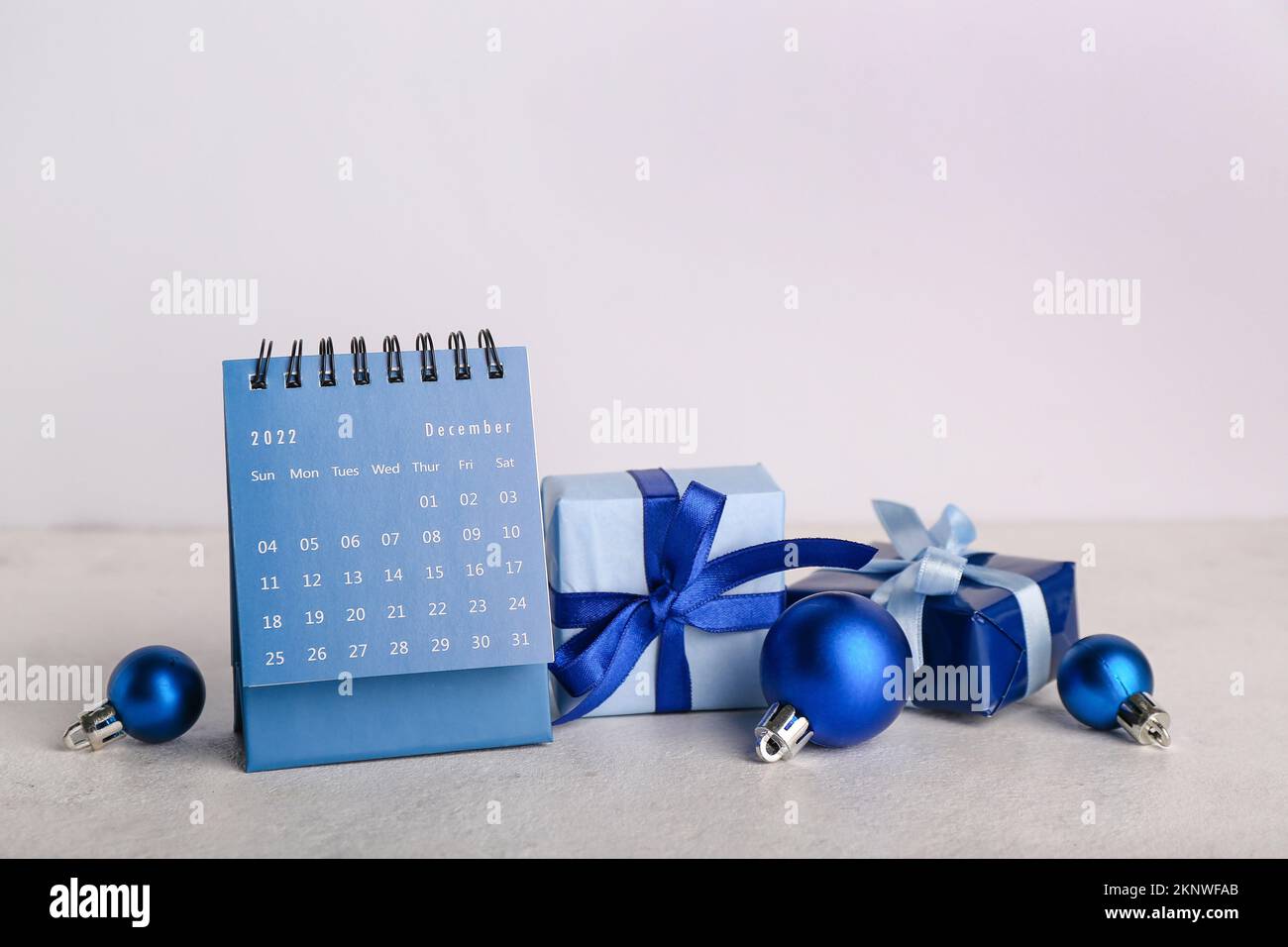 Flip calendar for December 2022 with Christmas balls and gifts on light ...