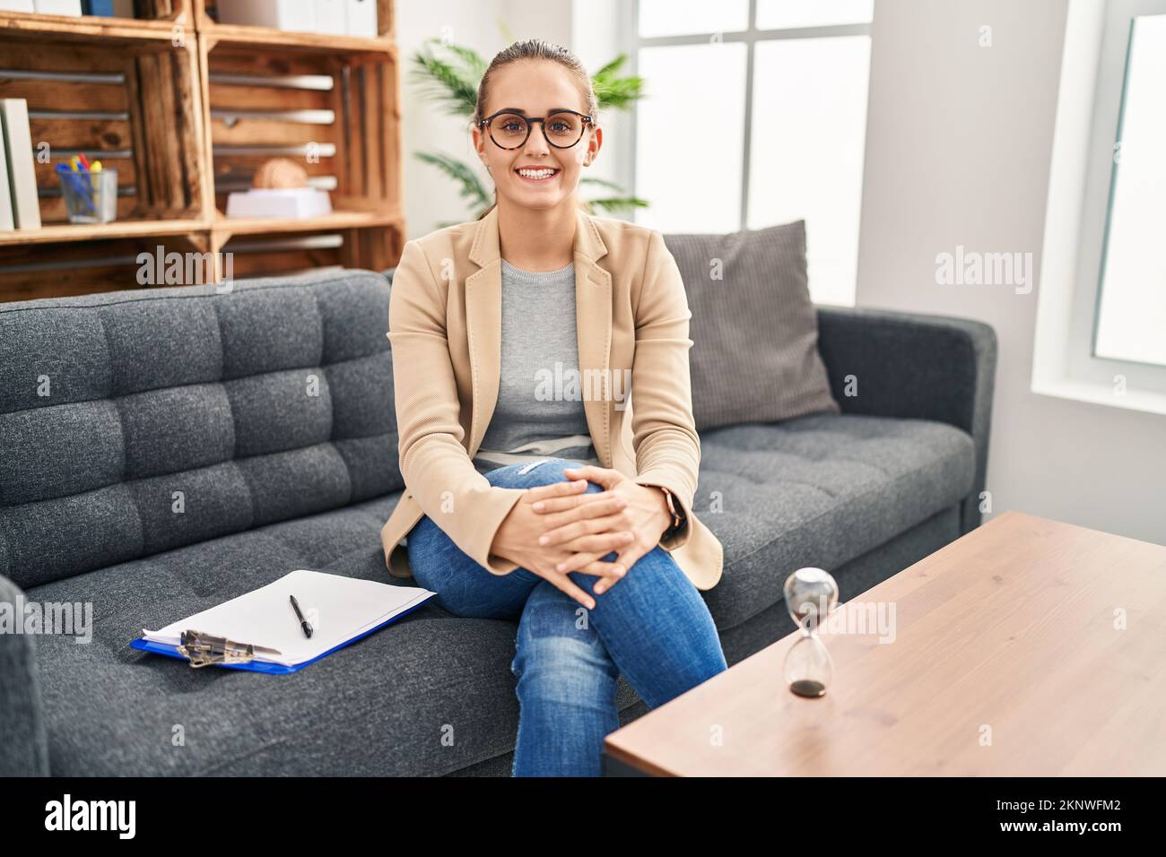 Young woman working at consultation office with a happy and cool smile ...