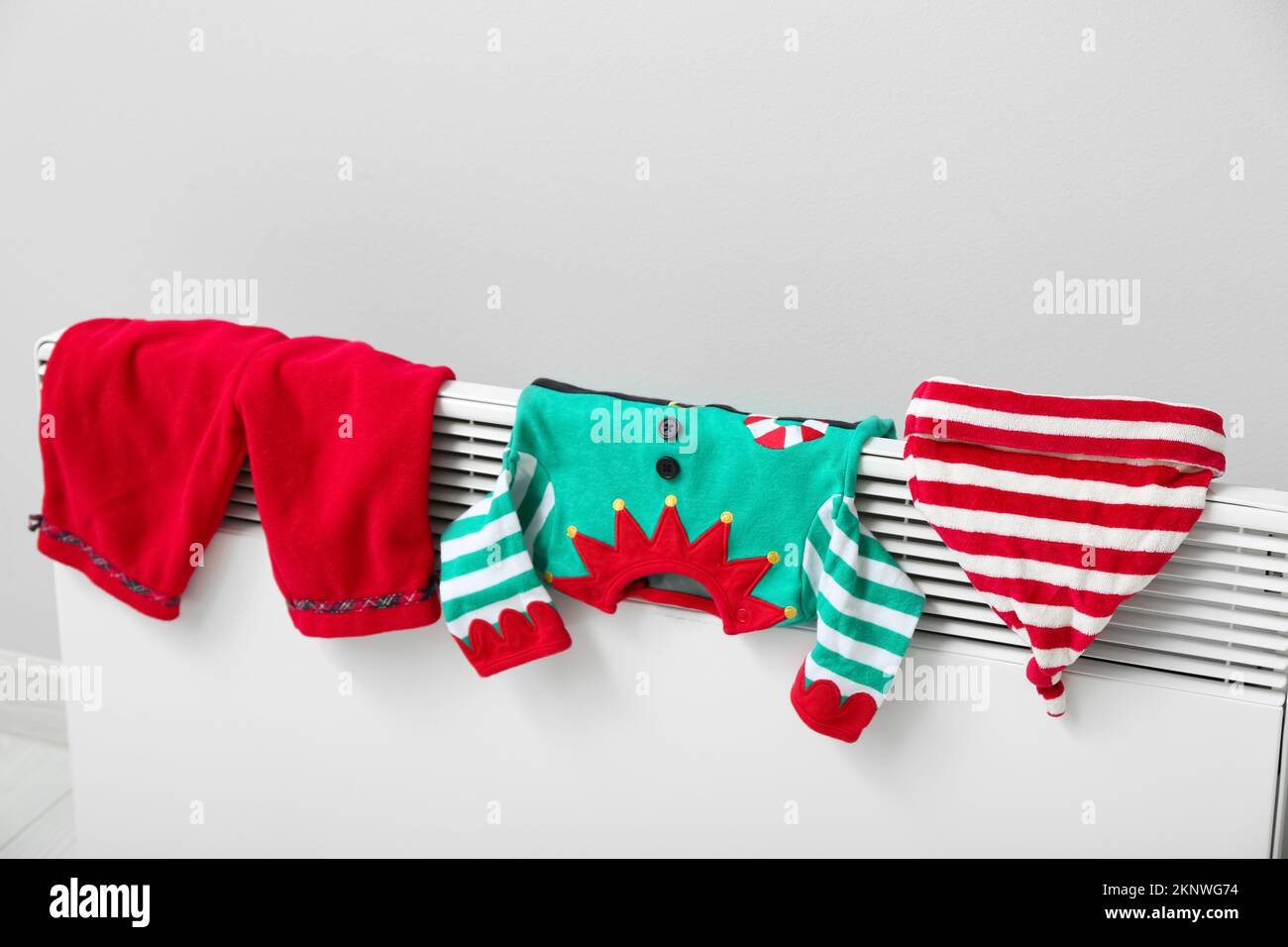 Baby elf costume drying on electric radiator near light wall Stock ...