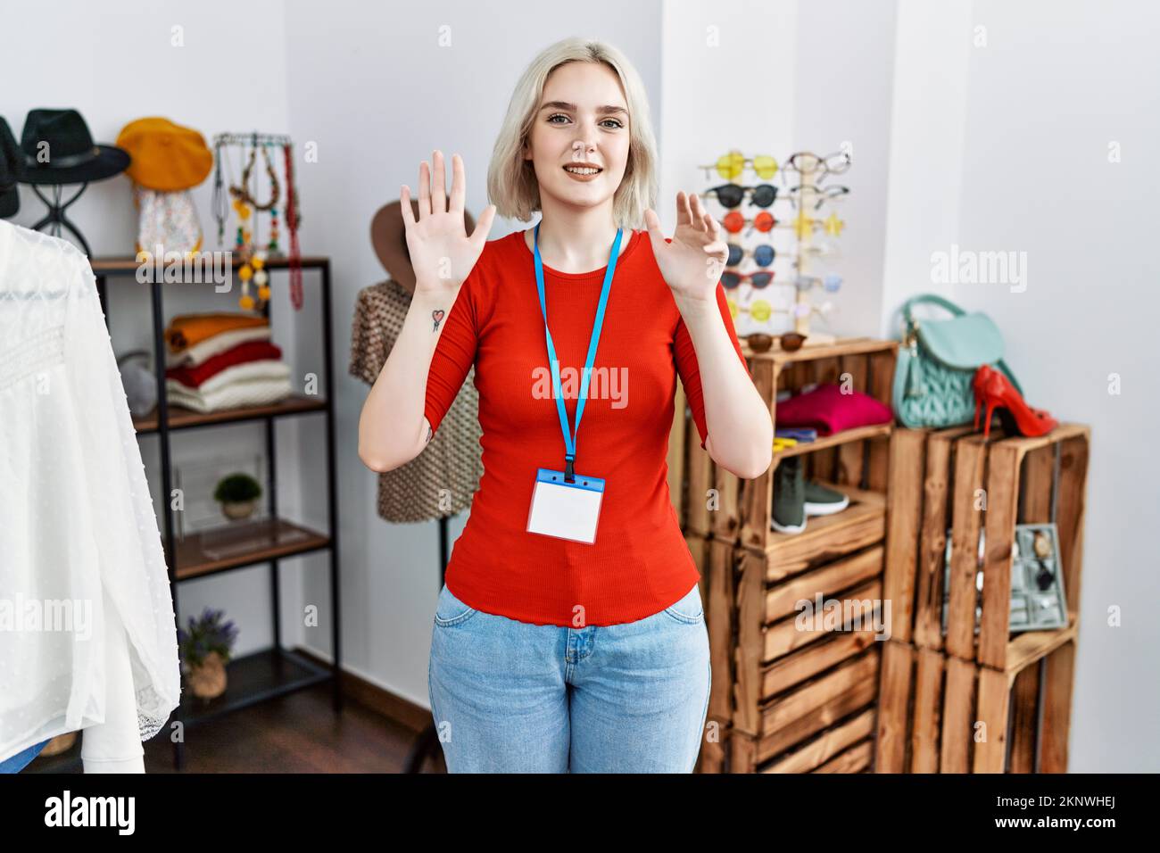 Young caucasian woman working as manager at retail boutique showing and ...