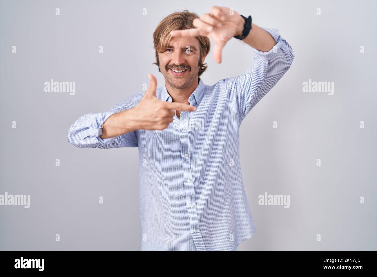 Caucasian man with mustache standing over white background smiling ...