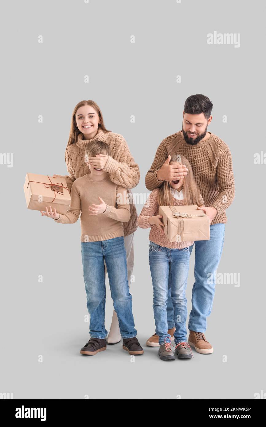 Happy parents surprising their little children with Christmas gifts on ...