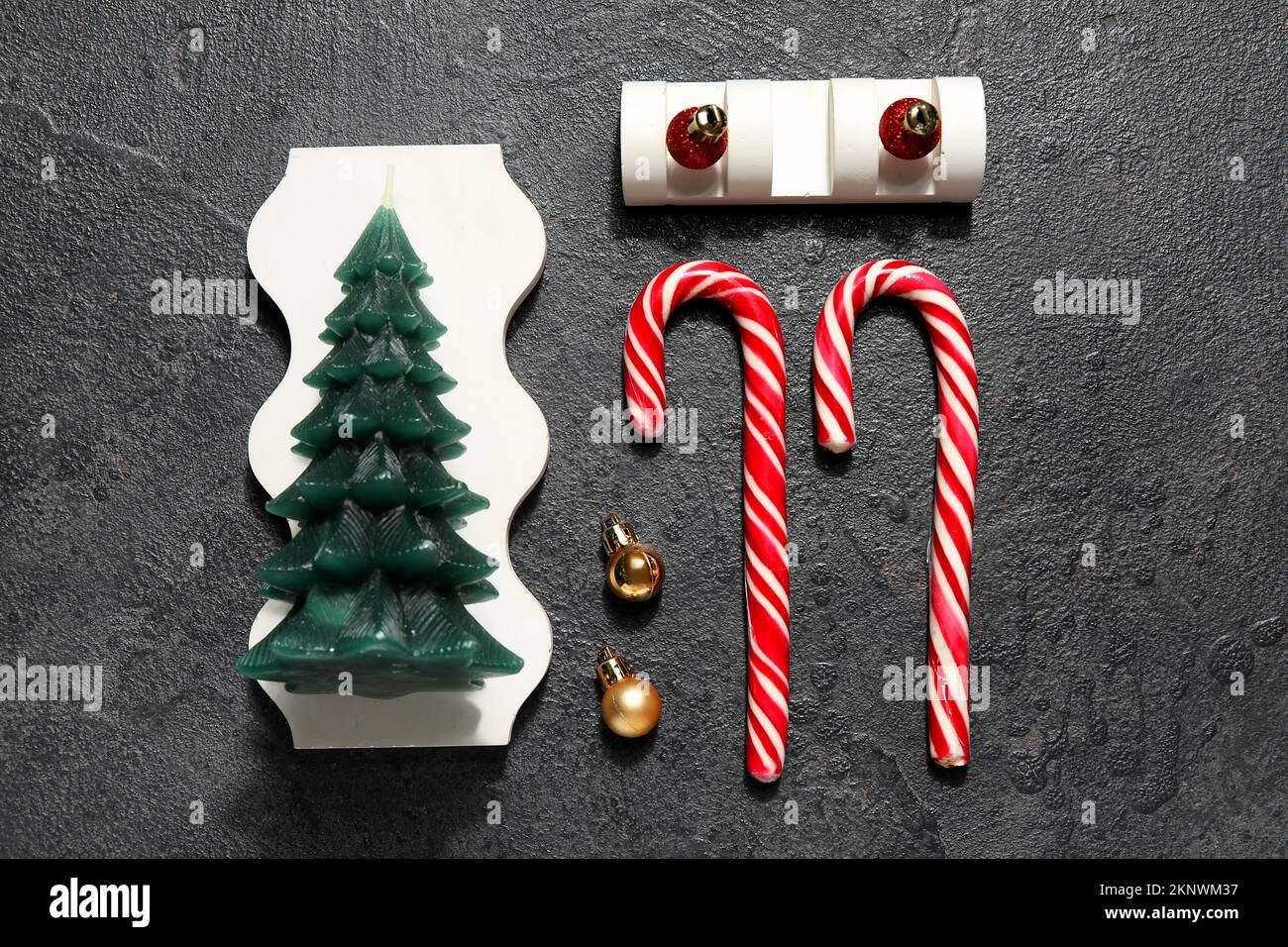Christmas tree candle with podiums, candy canes and balls on dark ...