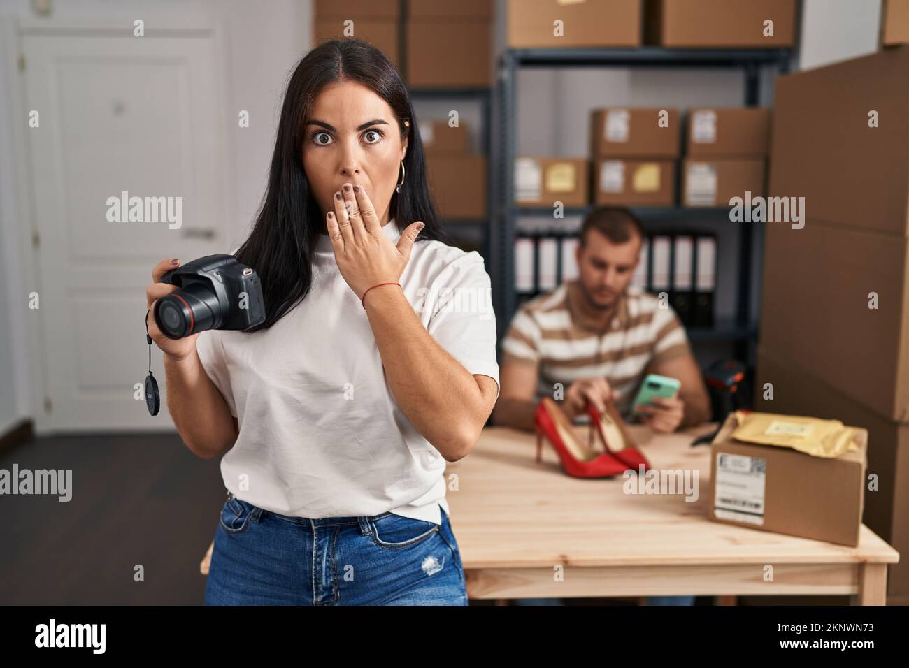 Young hispanic woman holding camera working at small business ecommerce ...