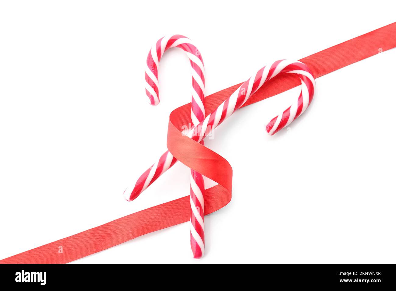 Sweet candy canes and red ribbon on white background Stock Photo - Alamy