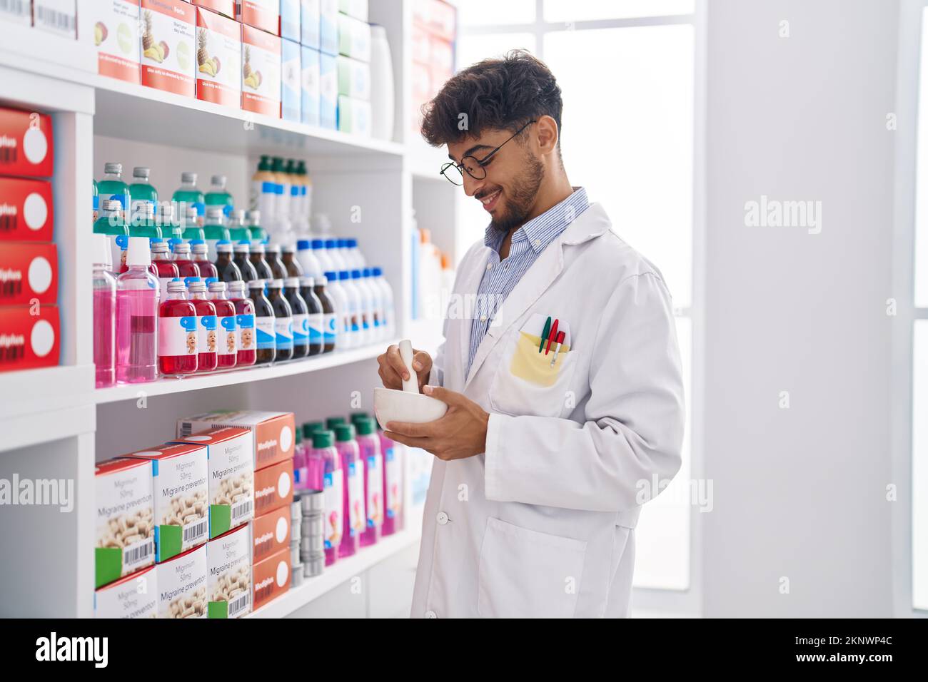Young arab man pharmacist smiling confident working at pharmacy Stock ...