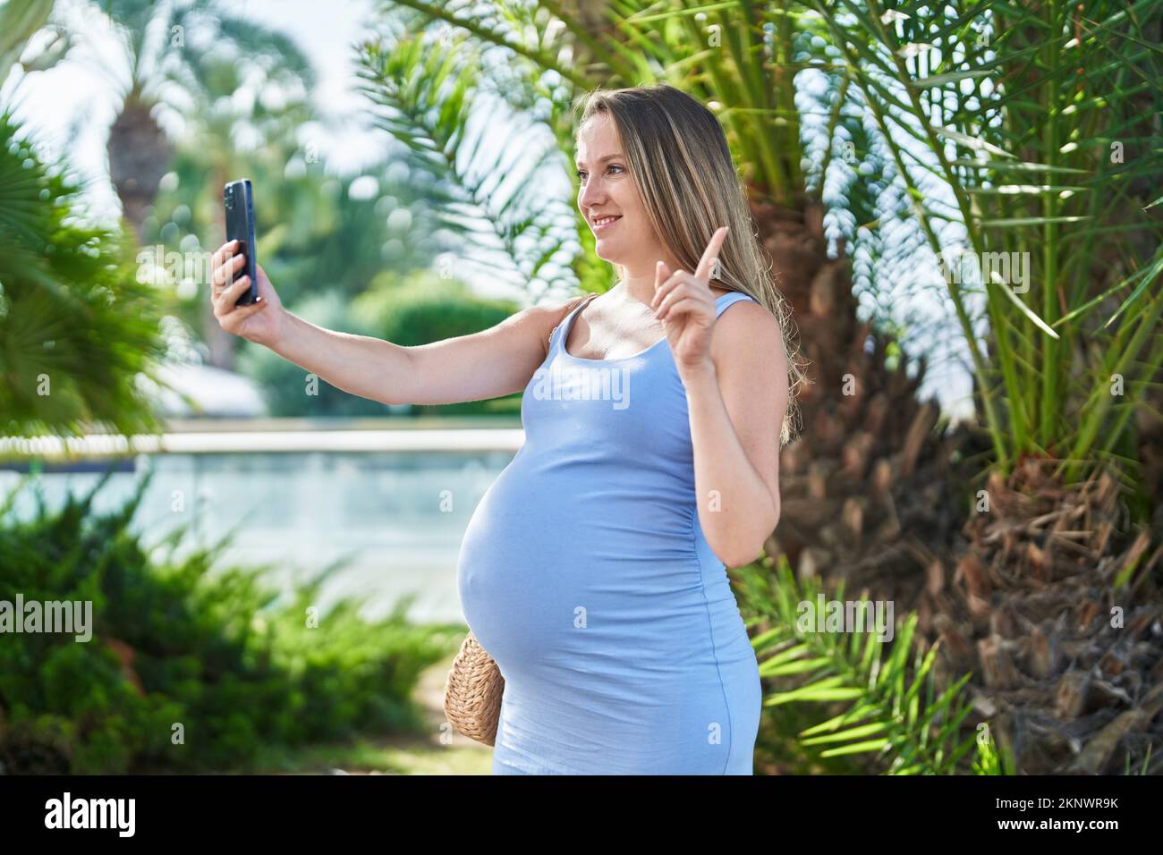 Young pregnant woman doing video call with smartphone smiling happy ...