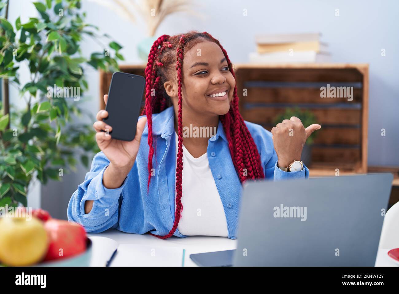 African american woman with braided hair holding smartphone showing ...
