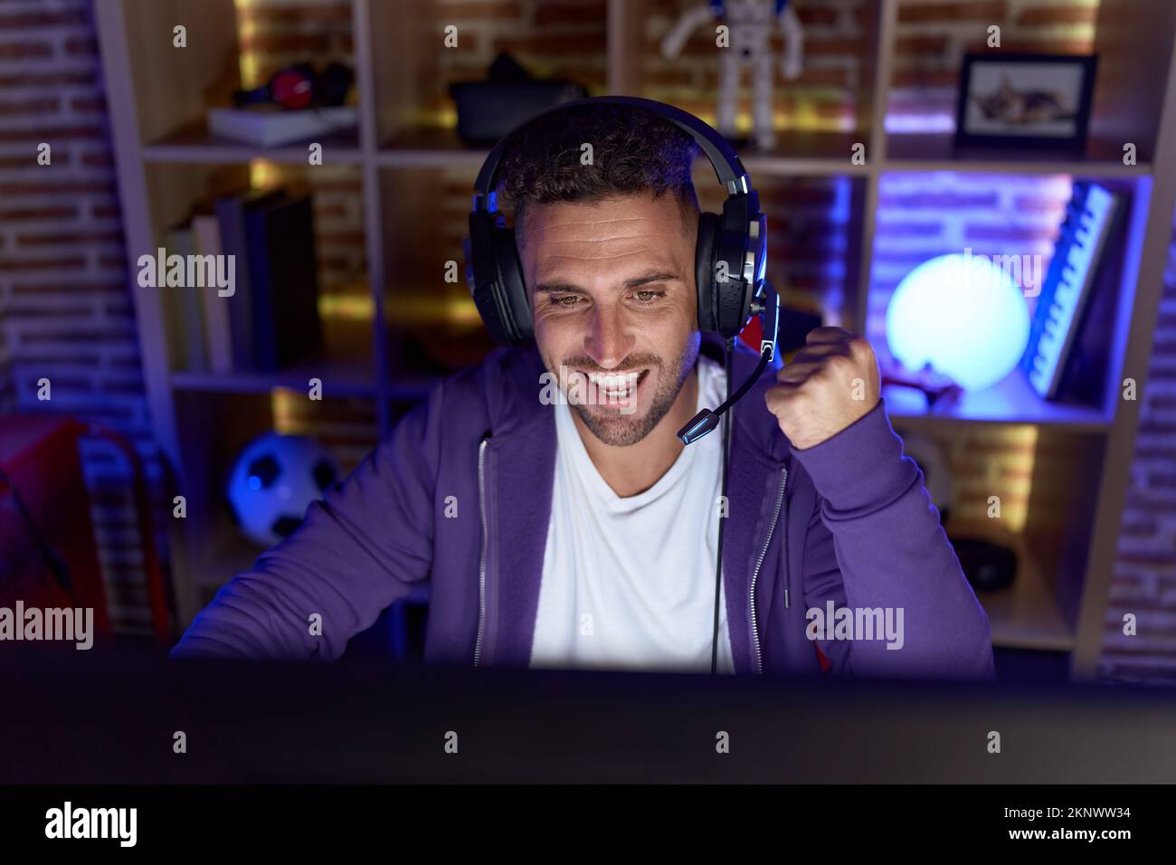 Young hispanic man streamer playing video game with winner expression ...