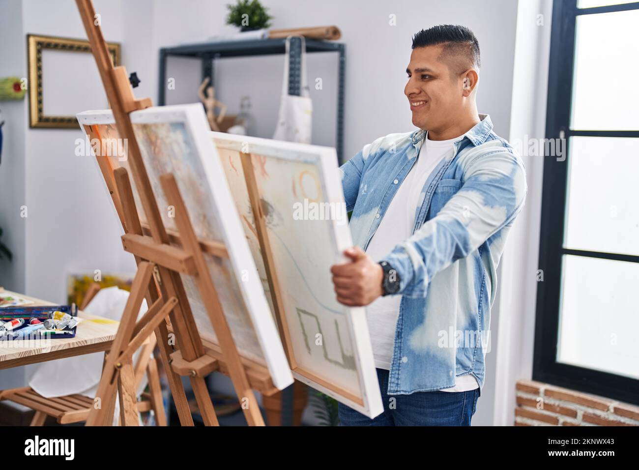 Young latin man artist smiling confident looking draw at art studio ...