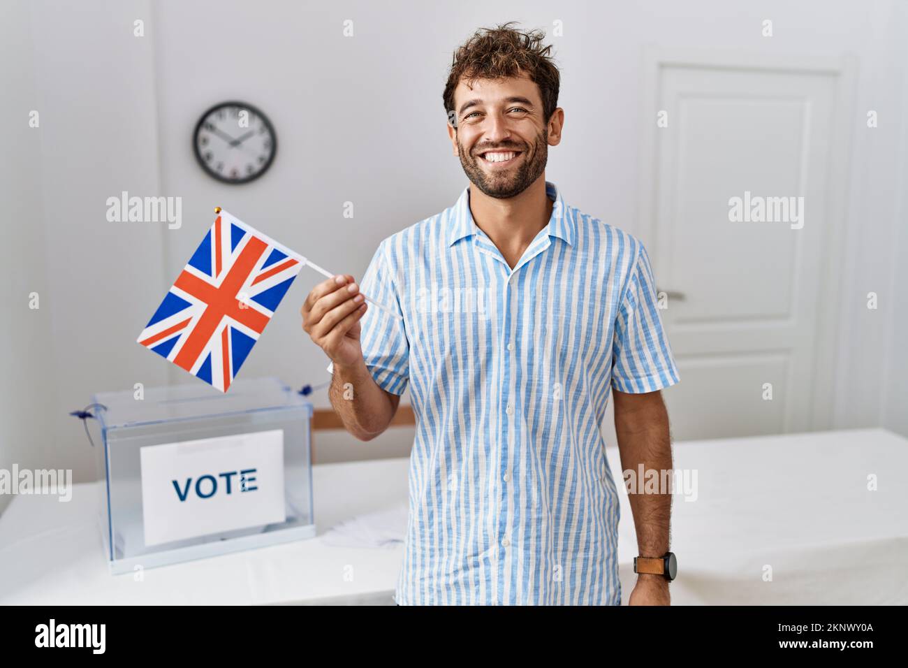 Young handsome man at political campaign election holding uk flag ...