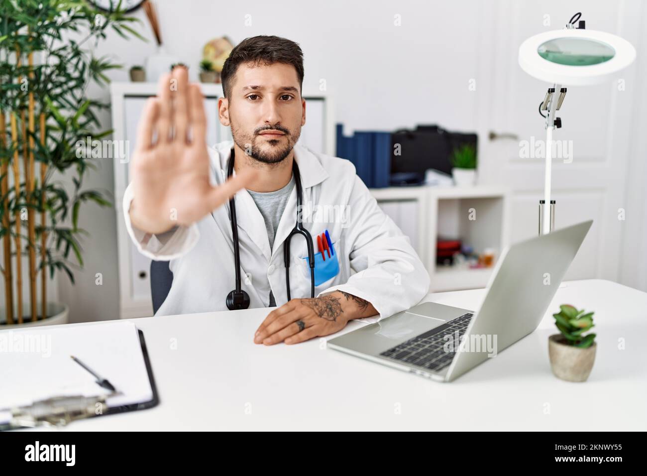 Young doctor working at the clinic using computer laptop doing stop ...