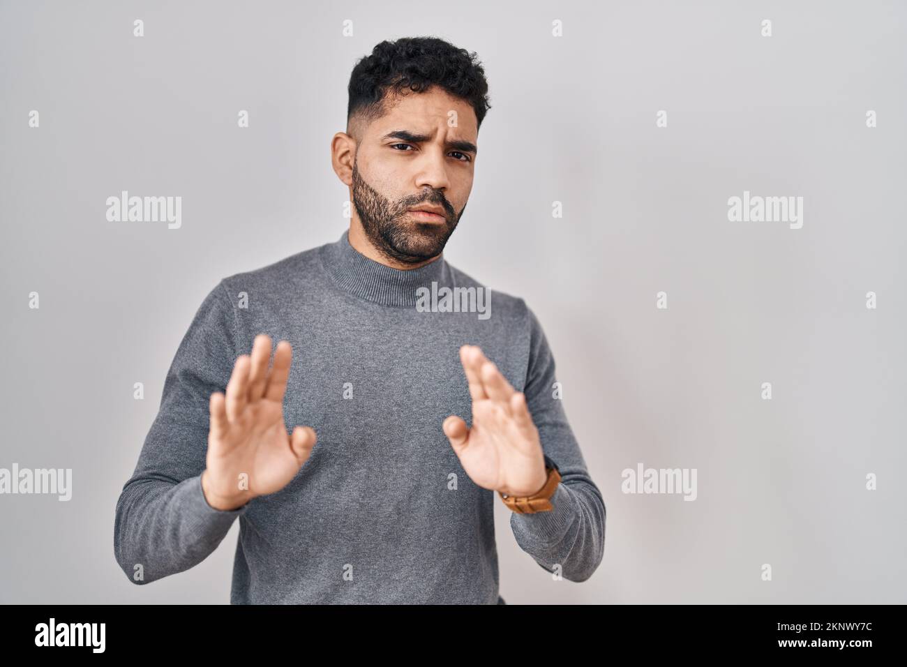 Hispanic man with beard standing over white background moving away ...
