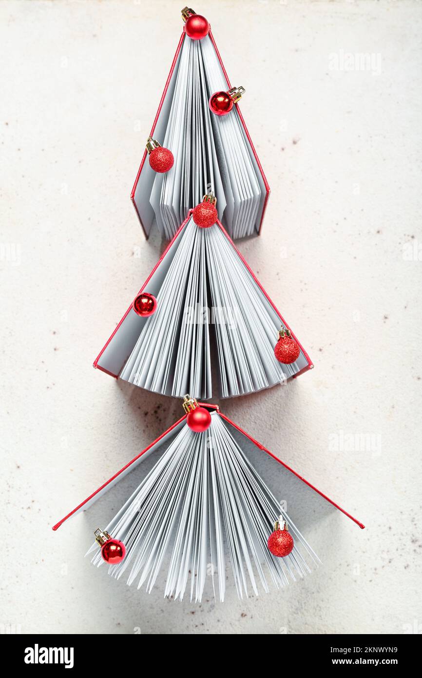 Christmas tree made of books and balls on light background Stock Photo ...