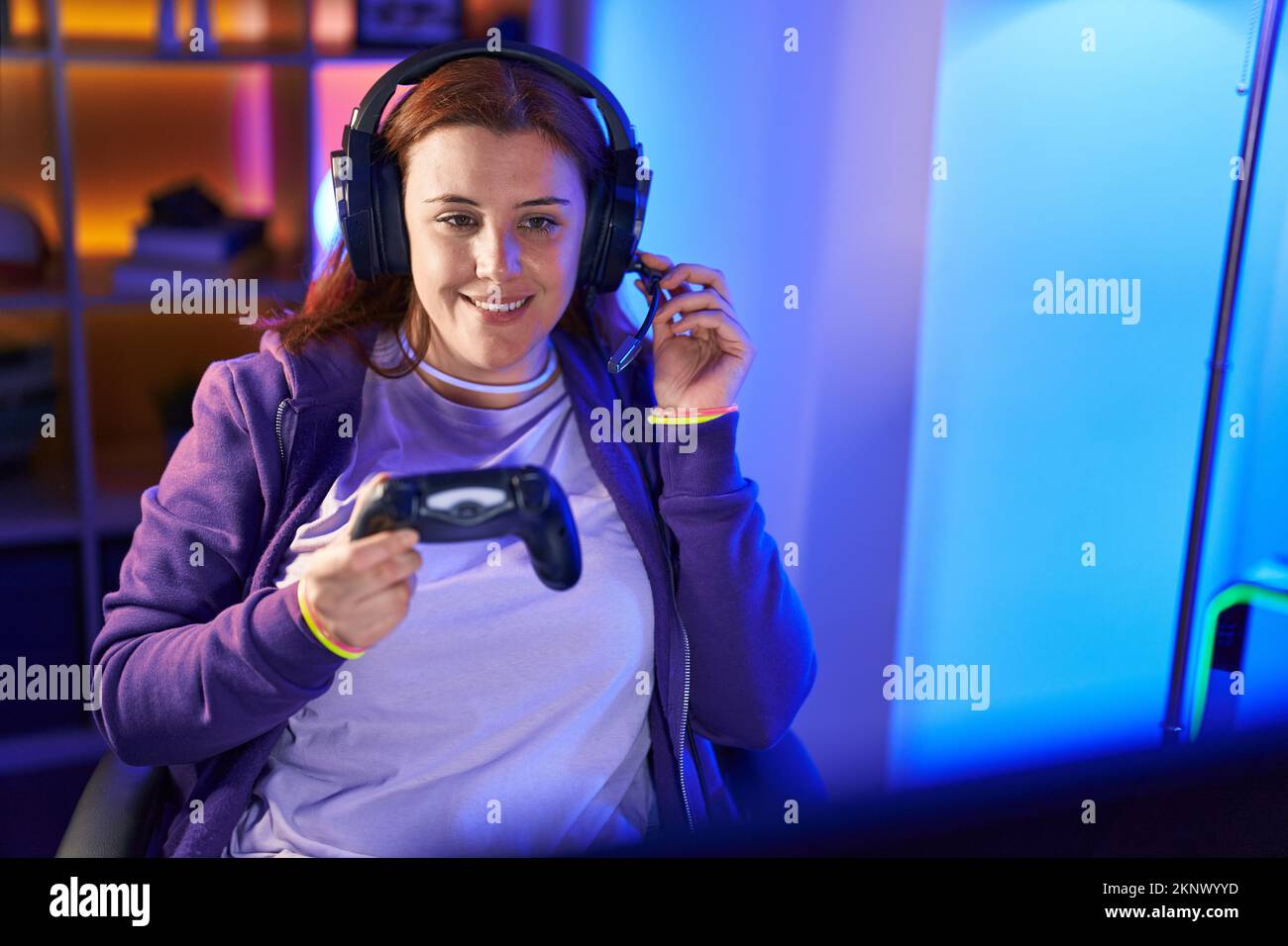 Young beautiful plus size woman streamer playing video game using ...