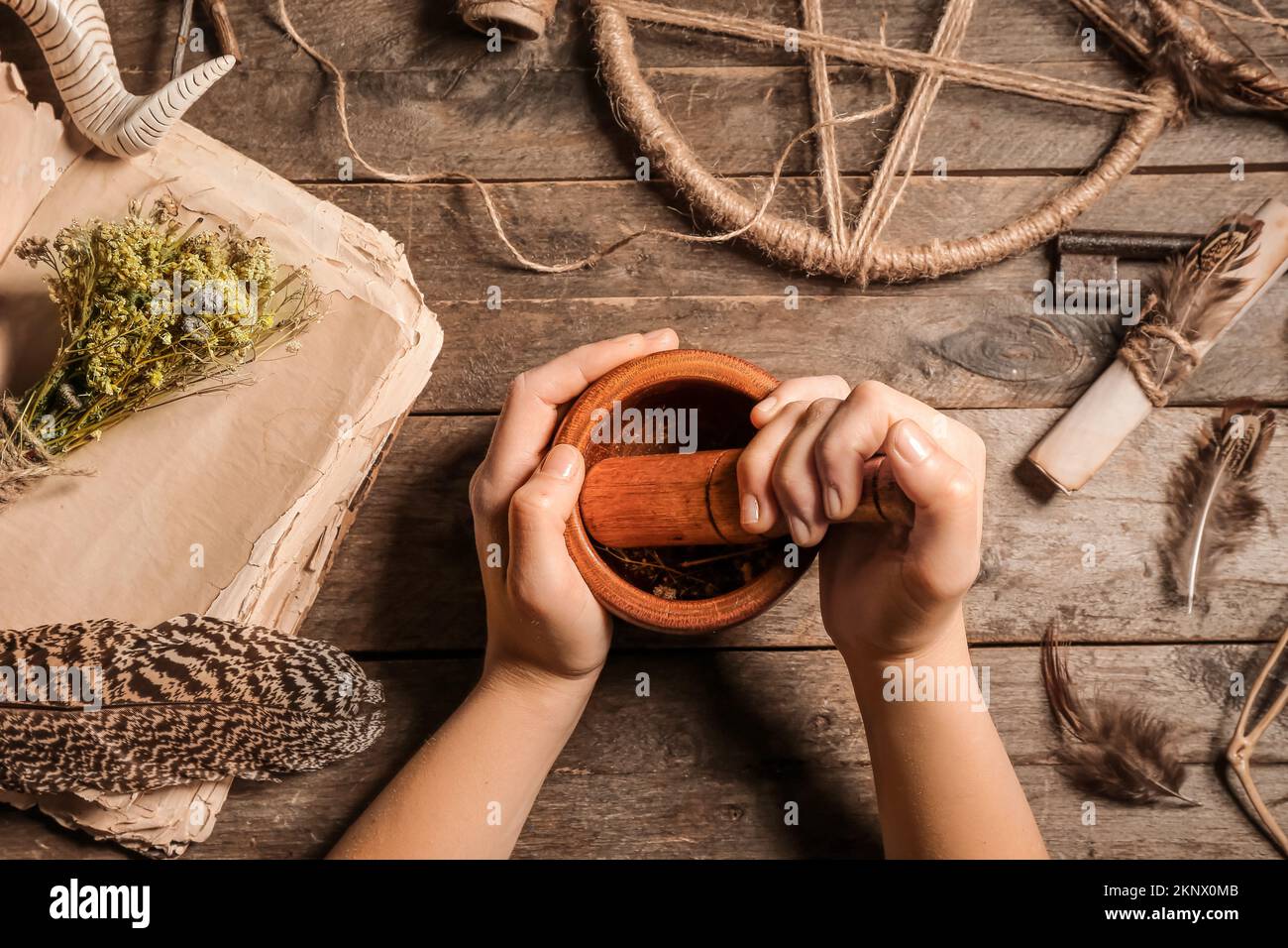 Young witch performing ritual at wooden table, top view Stock Photo - Alamy