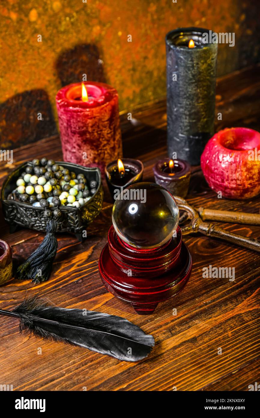 Crystal ball and magic attributes of fortune teller on wooden table ...