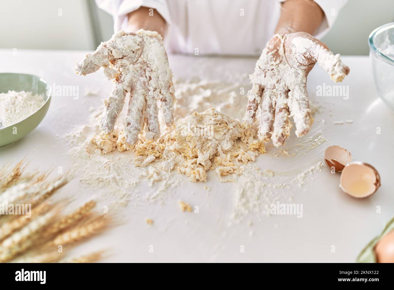 Young woman wearing cook uniform kneading flour at kitchen Stock Photo ...