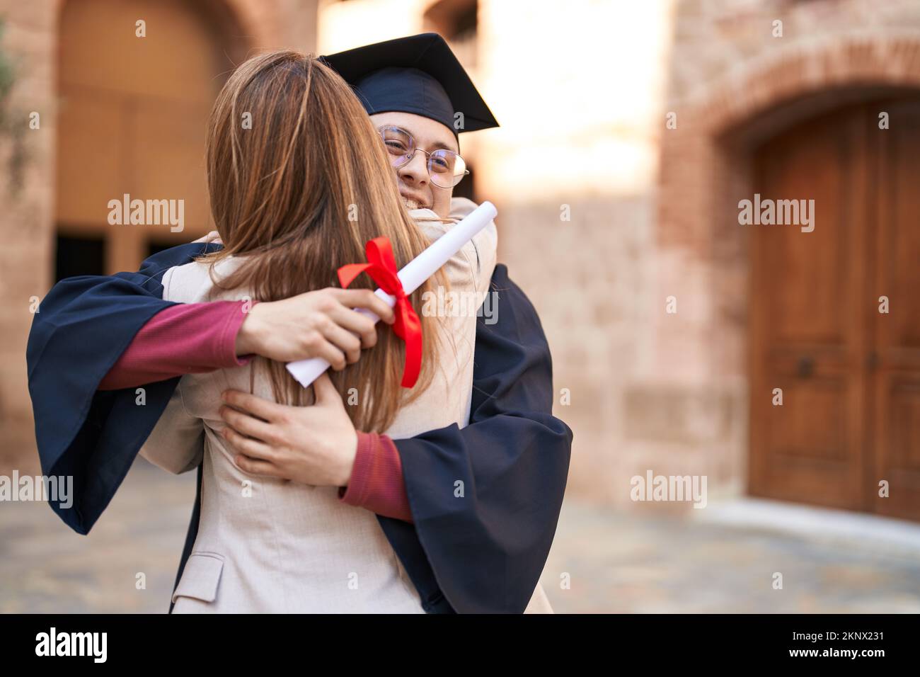 Man and woman mother and son hugging each other celebrating graduation ...