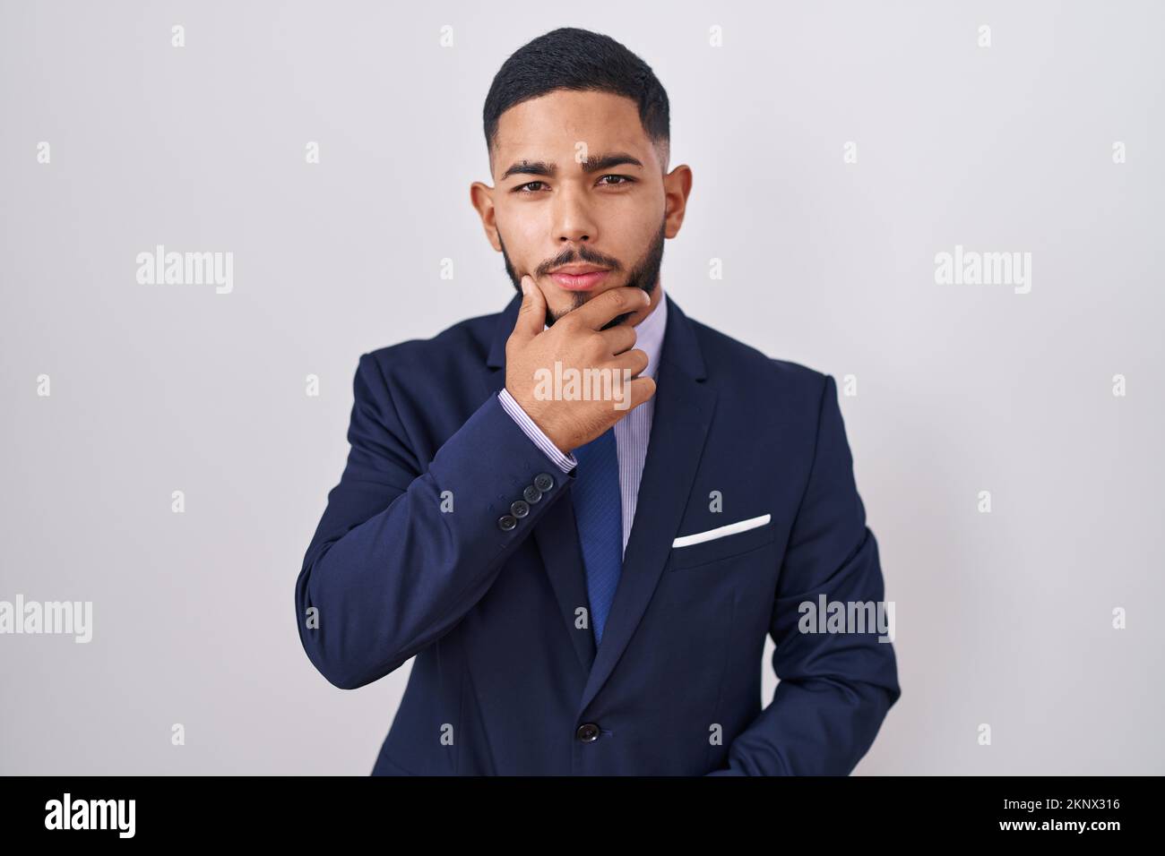 Young hispanic man wearing business suit and tie looking confident at ...
