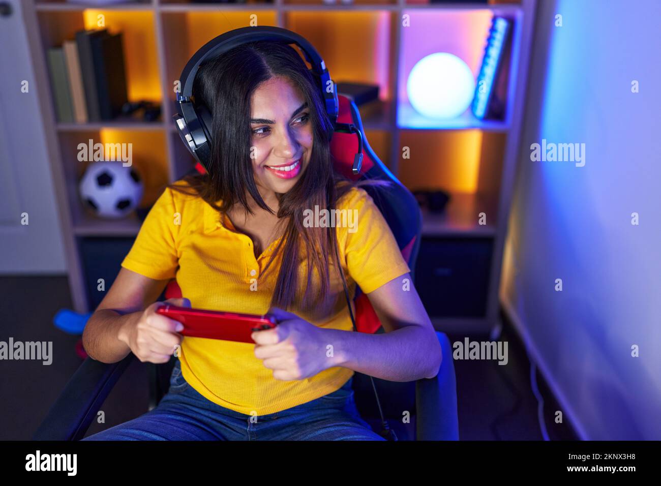 Young beautiful arab woman streamer playing video game using smartphone ...
