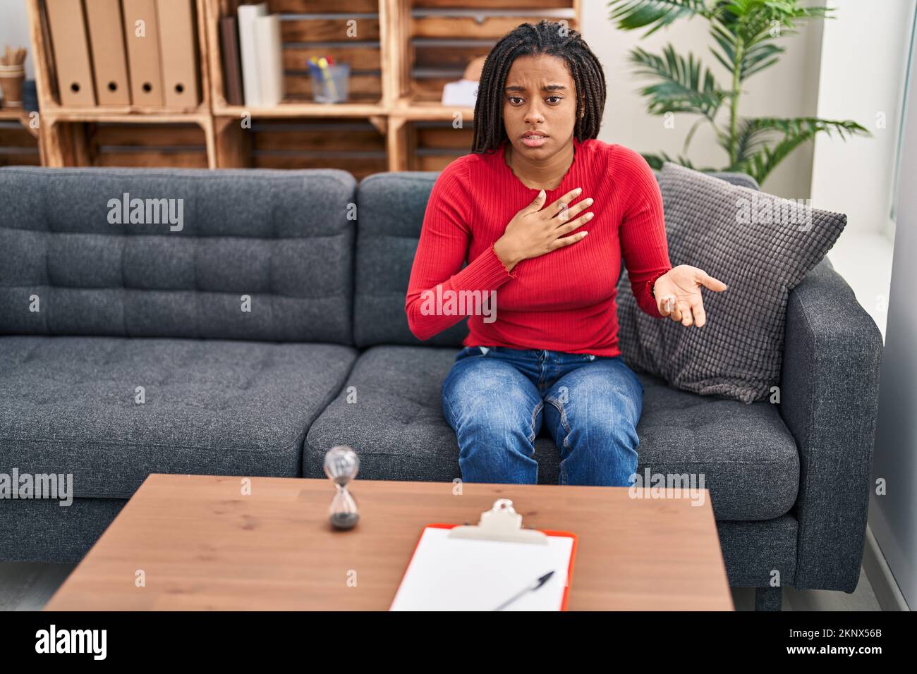 African american woman patient having psychology session touching chest ...