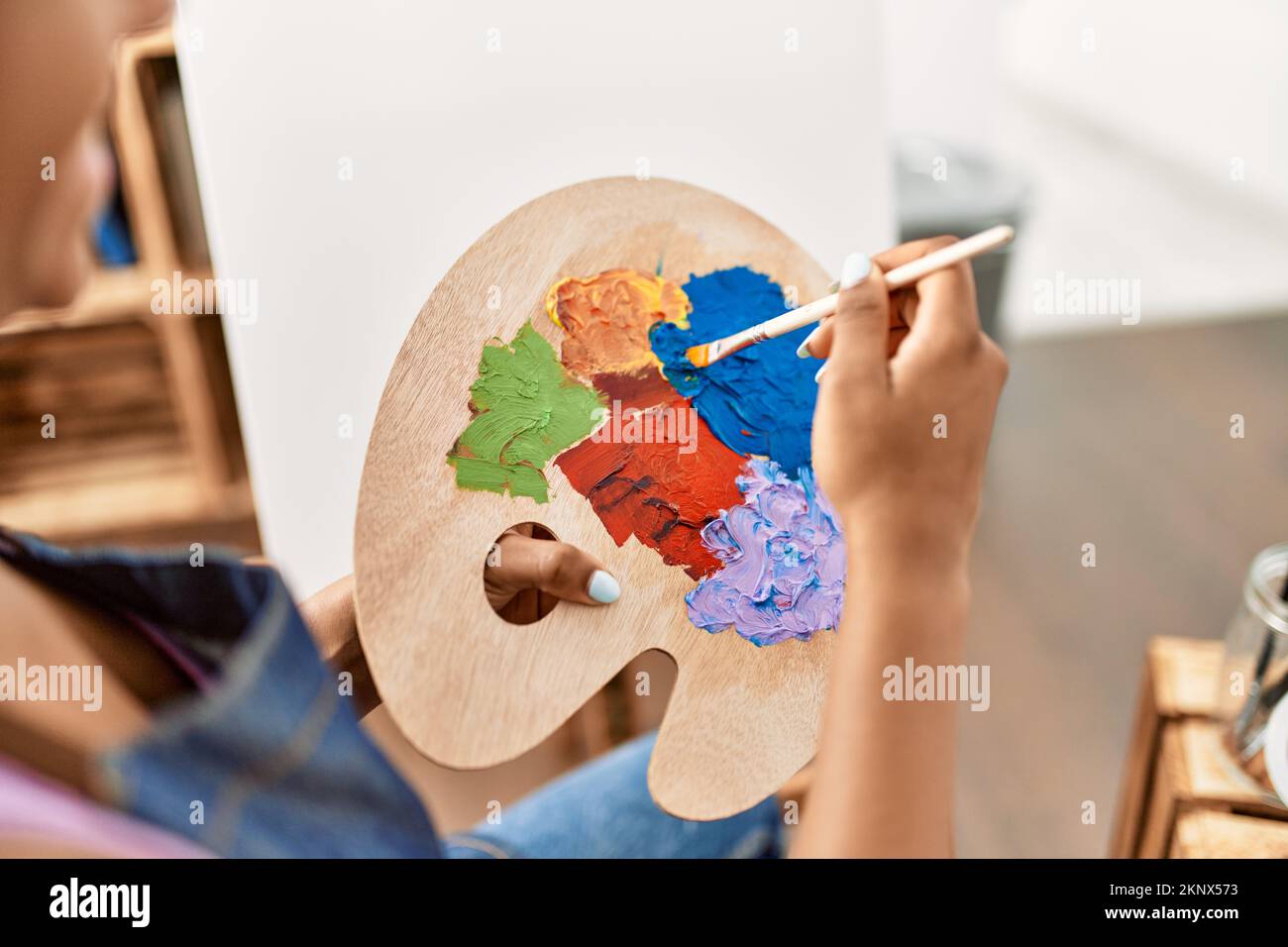 Young african american woman smiling confident mixing color on palette ...