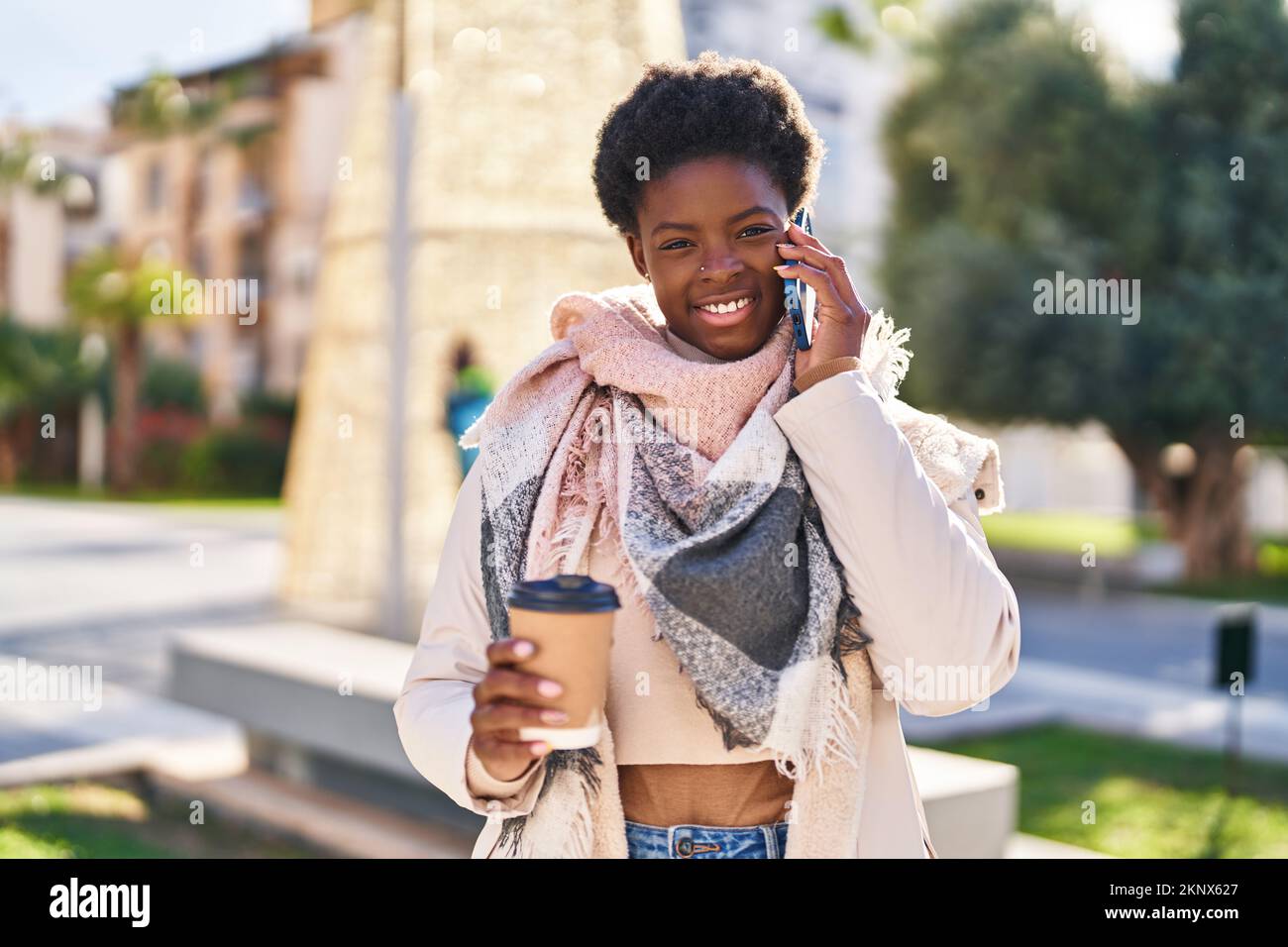 African american woman talking on the smartphone drinking coffee at ...