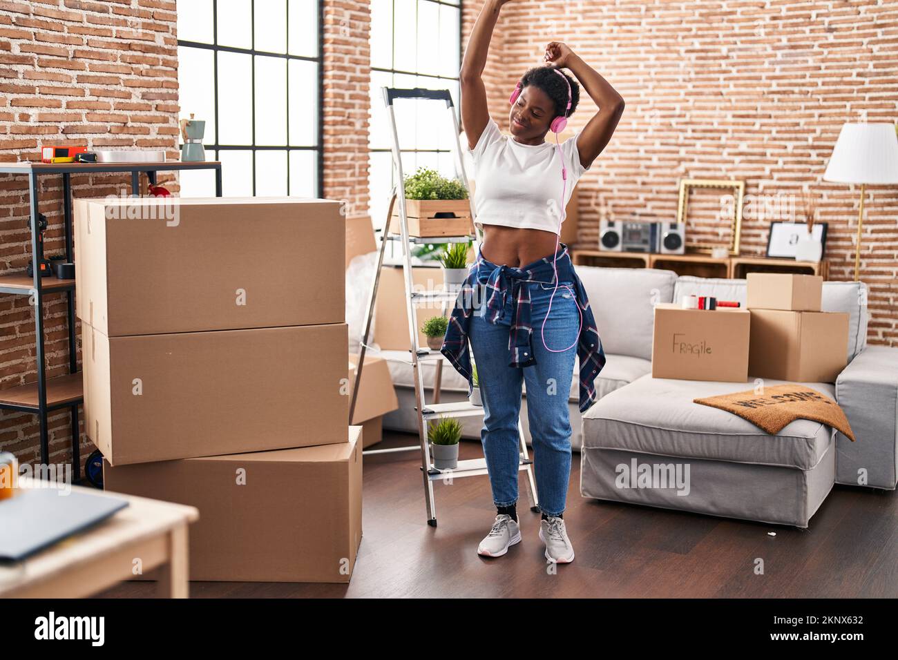 African american woman listening to music and dancing at new home Stock ...