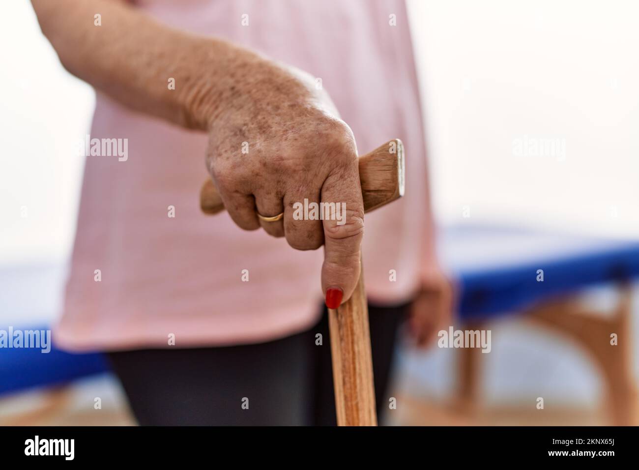 Senior grey-haired woman patient supporting with walking stick at ...