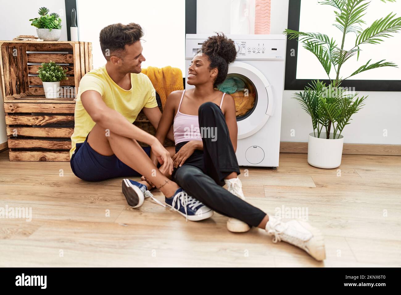 Man and woman couple hugging each other waiting for washing machine at ...
