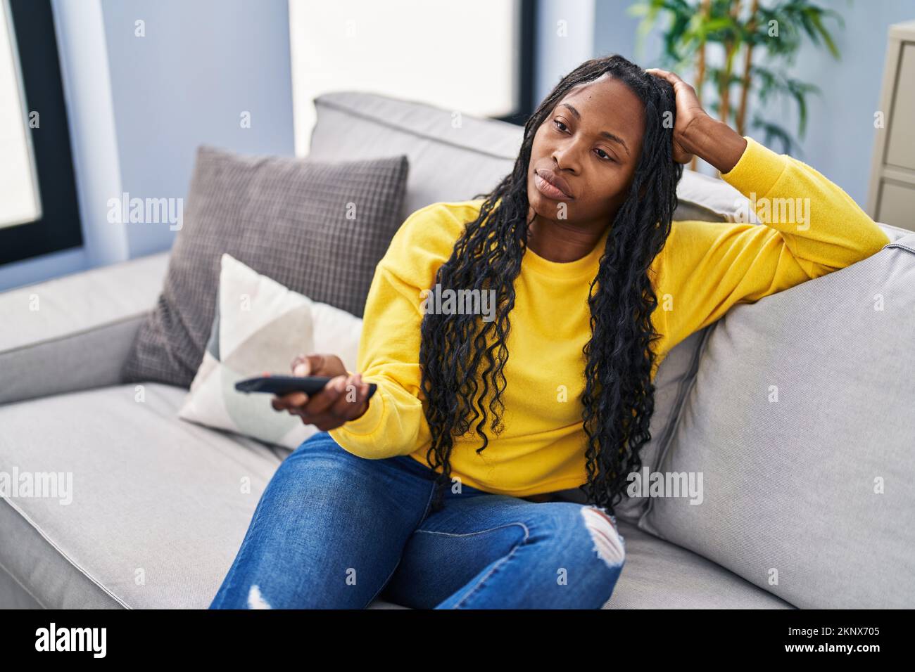 African american woman with boring expression watching tv at home Stock ...