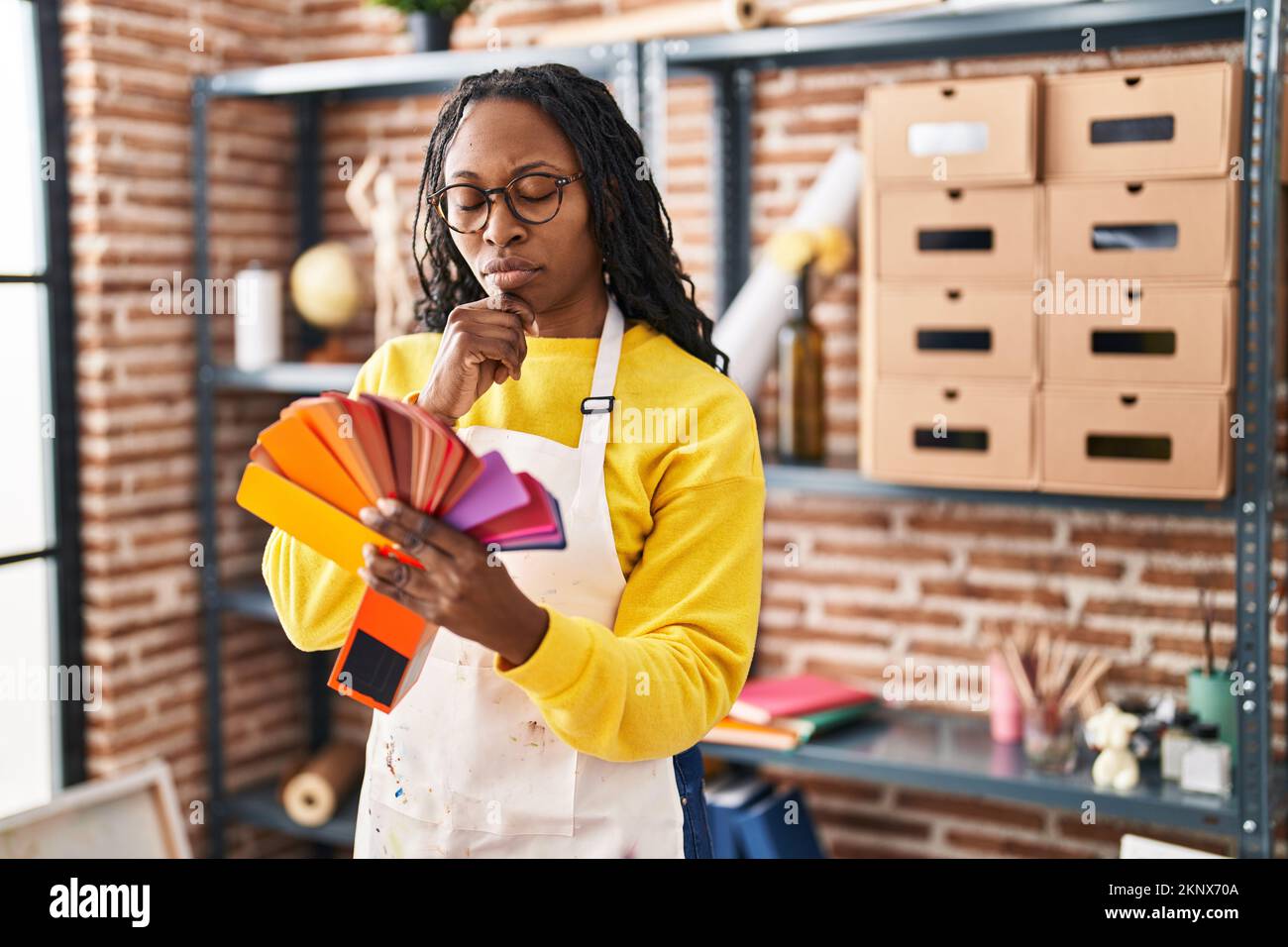 African american woman artist choosing paint color at art studio Stock ...