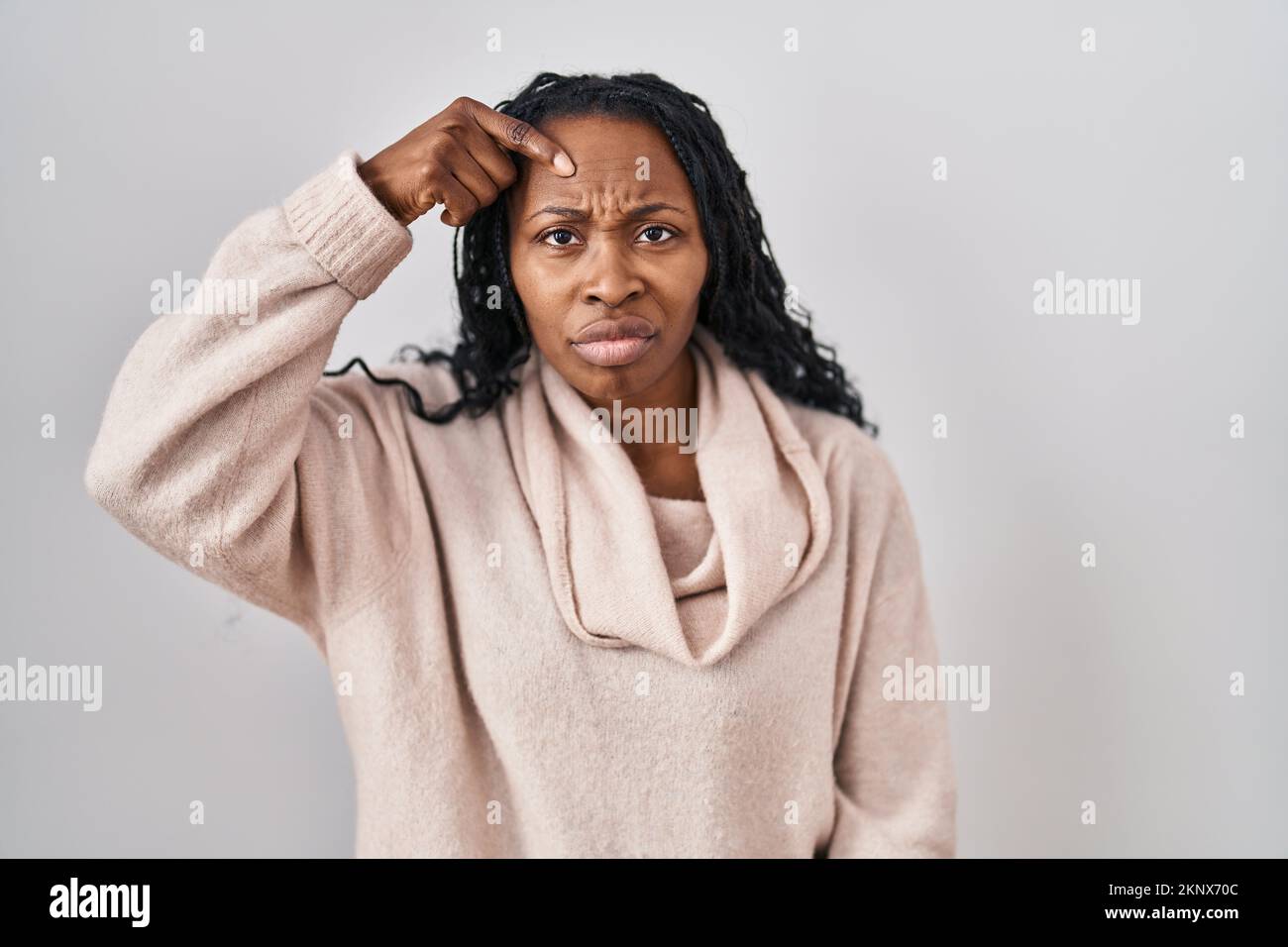 African woman standing over white background pointing unhappy to pimple ...