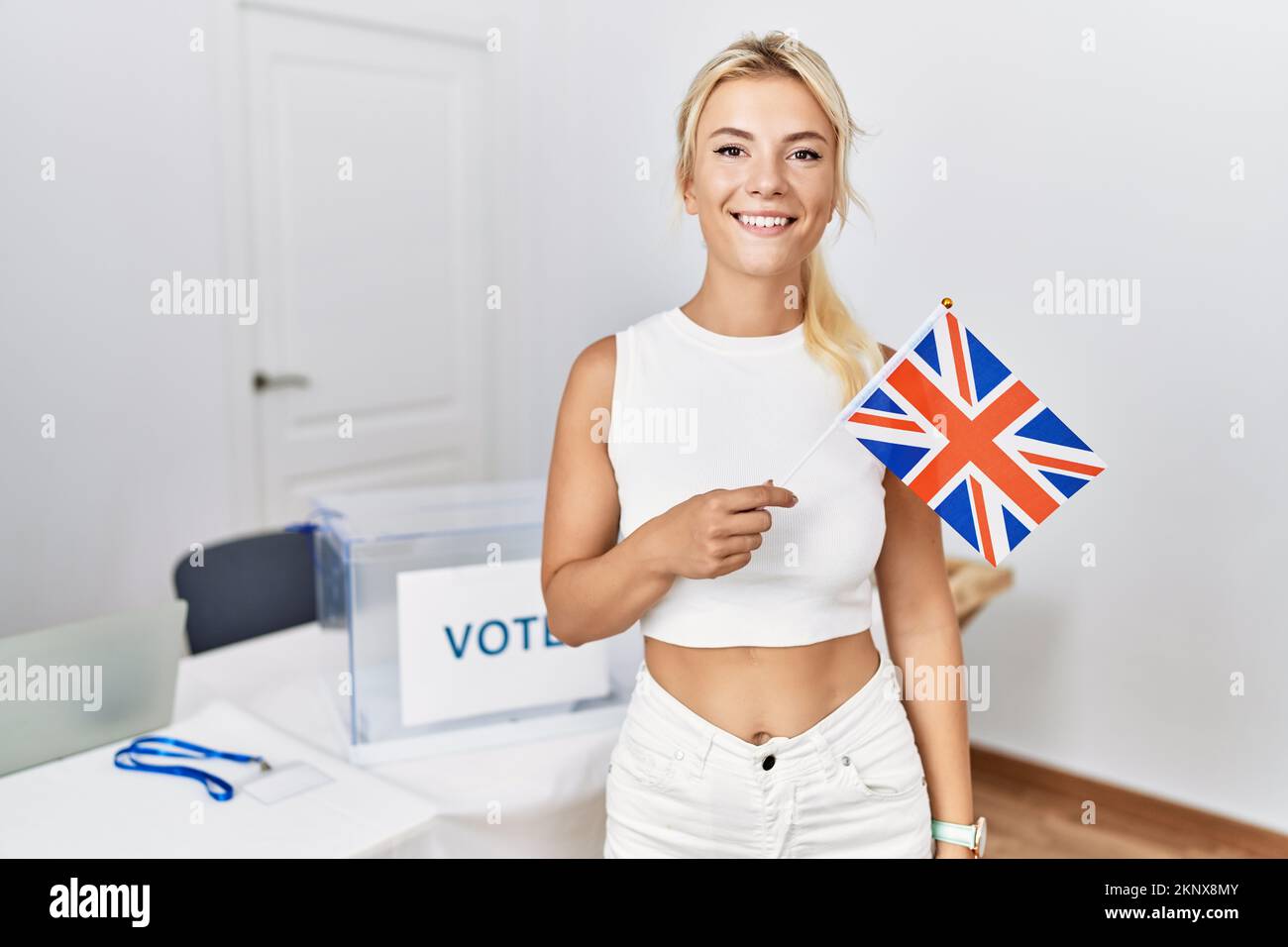Young caucasian woman at political campaign election holding uk flag ...