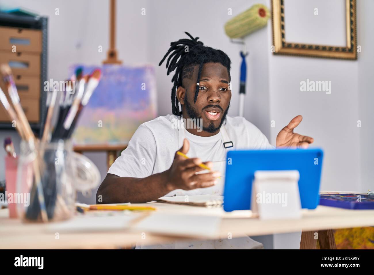 African american woman having video call drawing on notebook at art ...