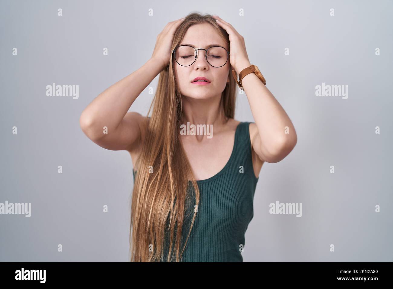 Young caucasian woman standing over white background suffering from ...