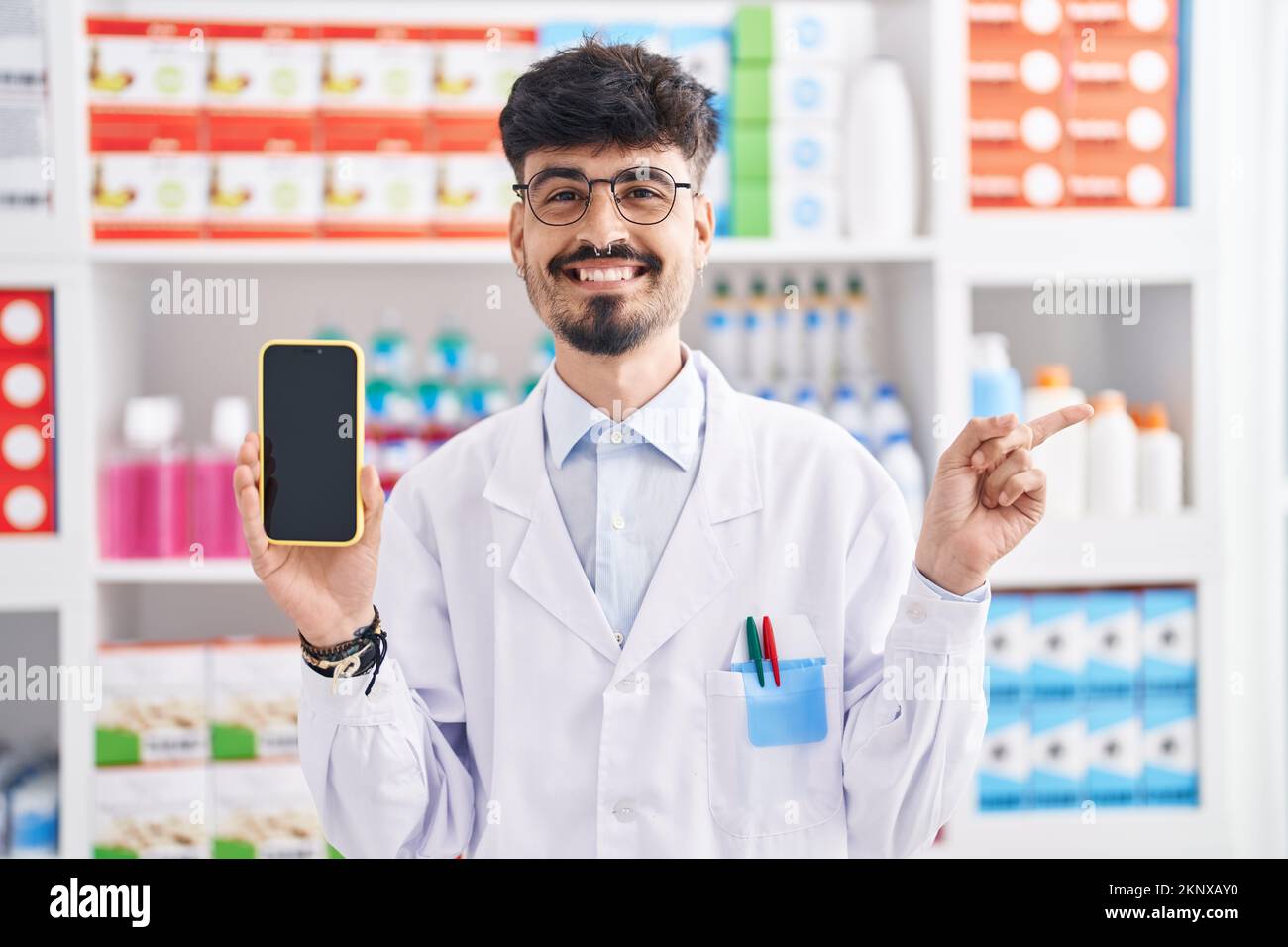 Young hispanic man with beard working at pharmacy drugstore showing ...