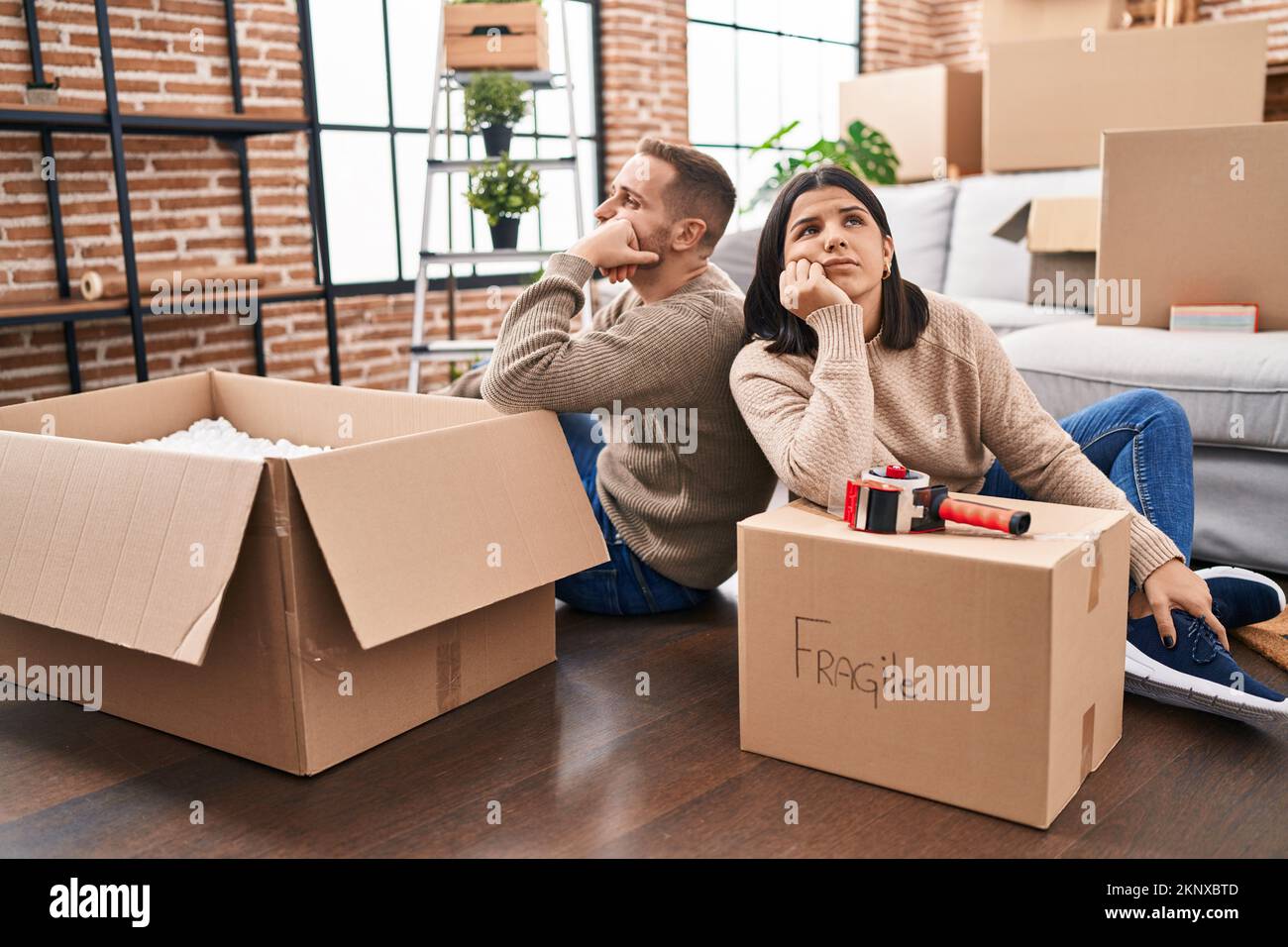Man and woman couple packing fragile cardboard box at new home Stock Photo - Alamy