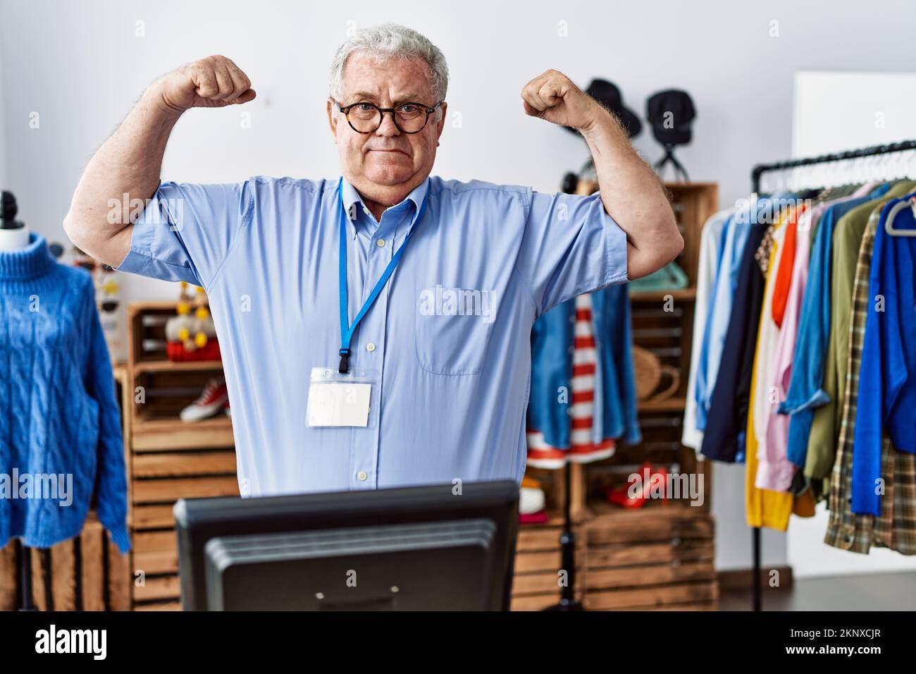 Senior man with grey hair working as manager at retail boutique showing ...
