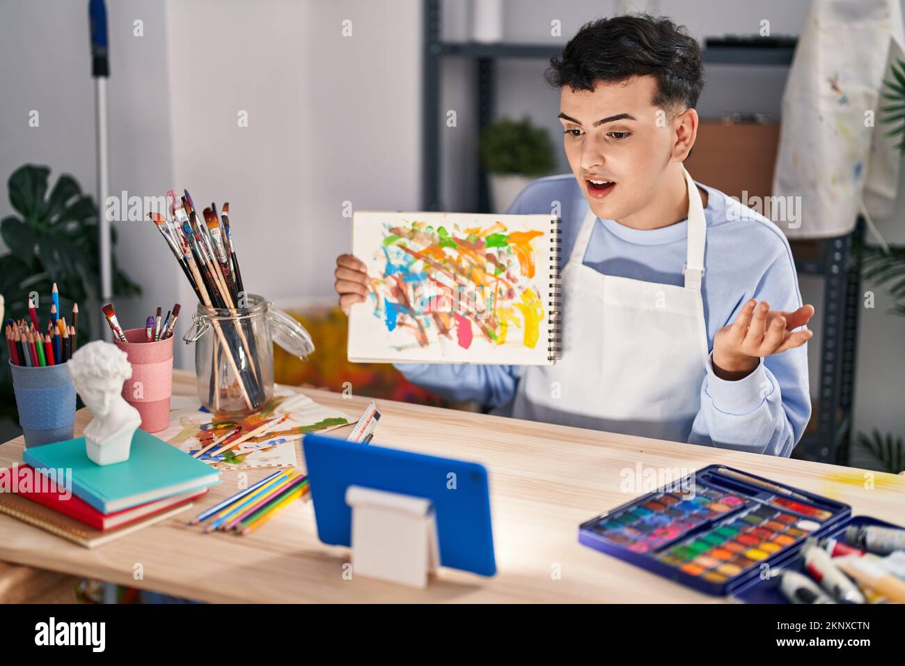 Young non binary man artist having online drawing class at art studio ...