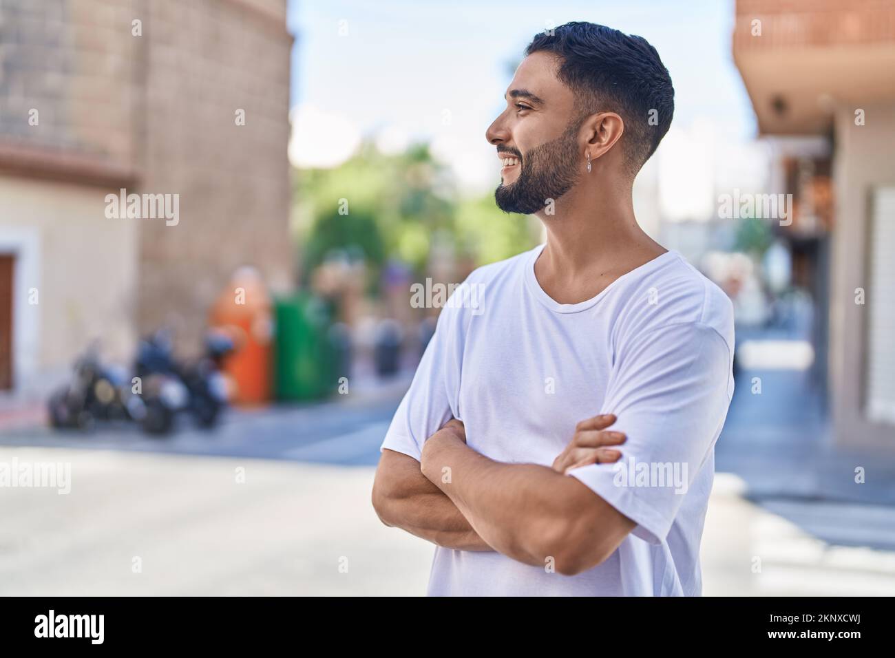 Young arab man standing with arms crossed gesture at street Stock Photo ...