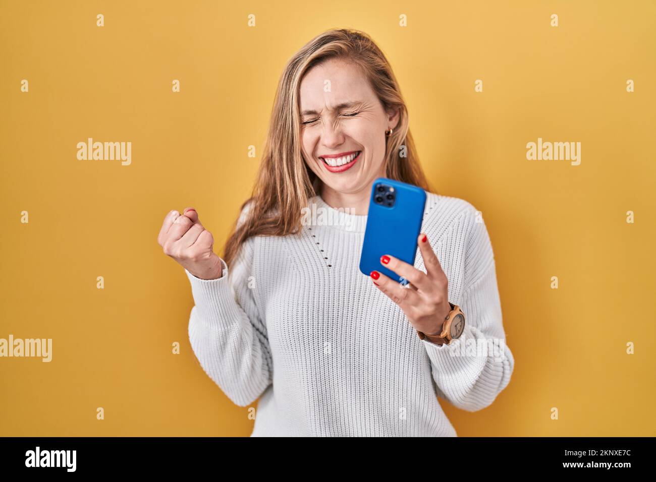 Young blonde woman using smartphone typing message very happy and ...