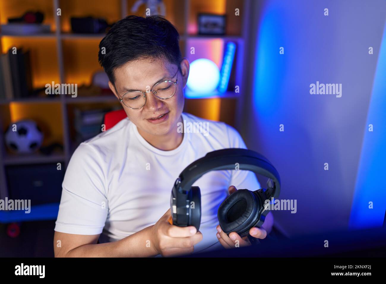 Young chinese man streamer smiling confident holding headphones at ...