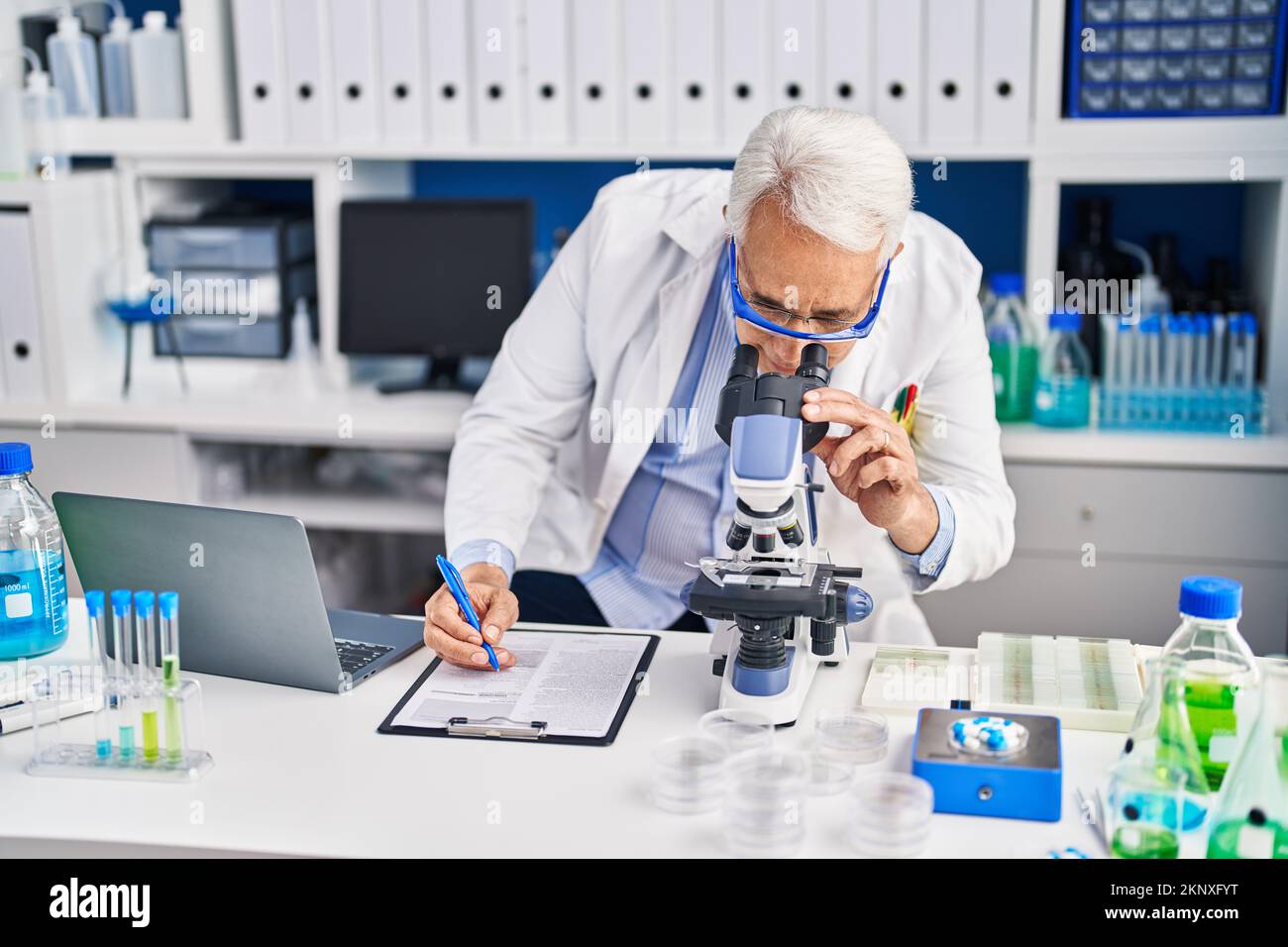 Senior man scientist using microscope working at laboratory Stock Photo - Alamy