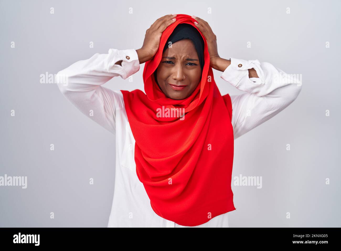 Young arab woman wearing traditional islamic hijab scarf suffering from ...