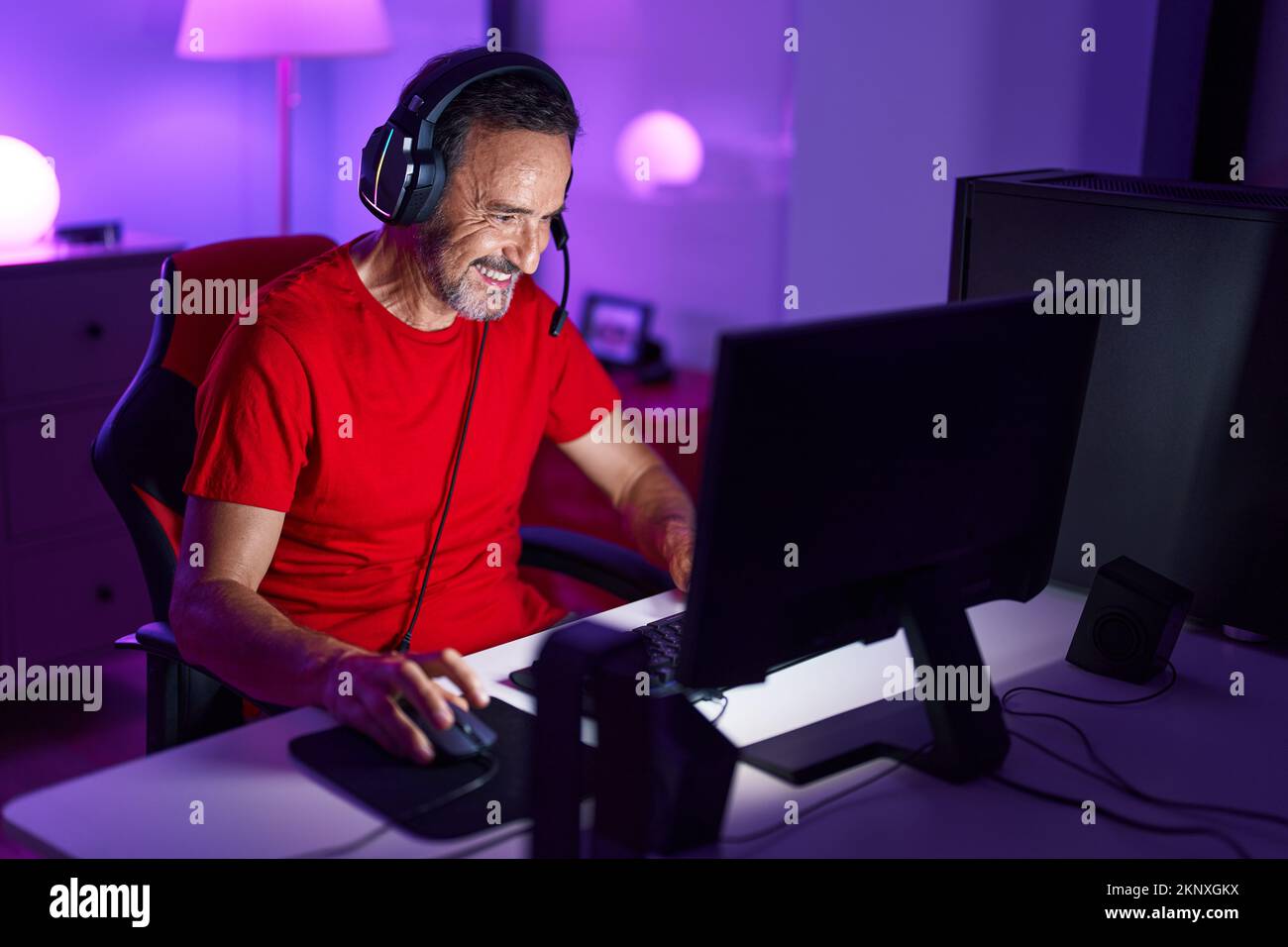 Middle age man streamer playing video game using computer at gaming ...