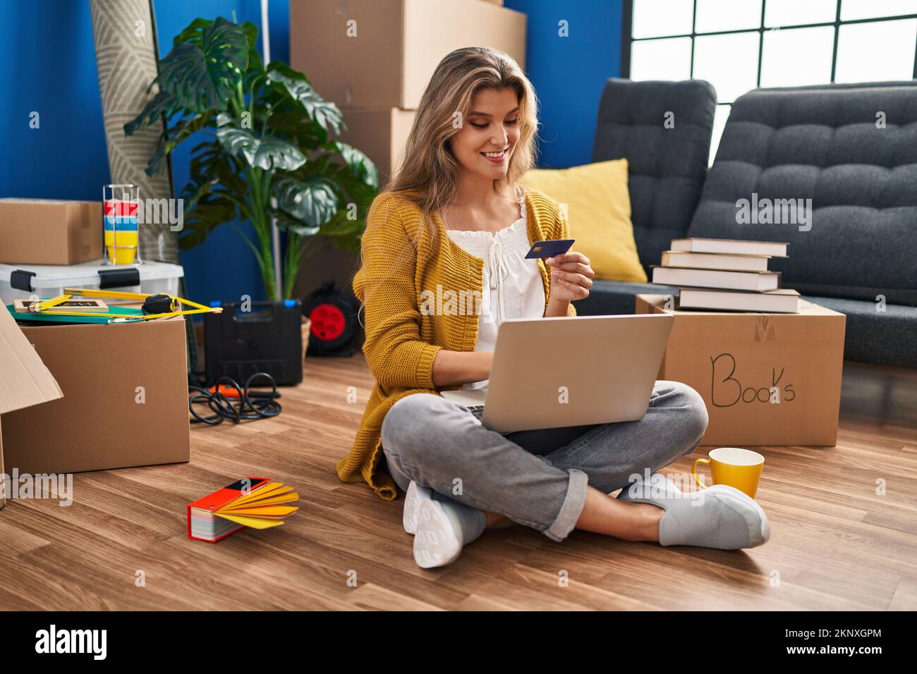 Young blonde woman smiling confident using laptop and credit card at ...