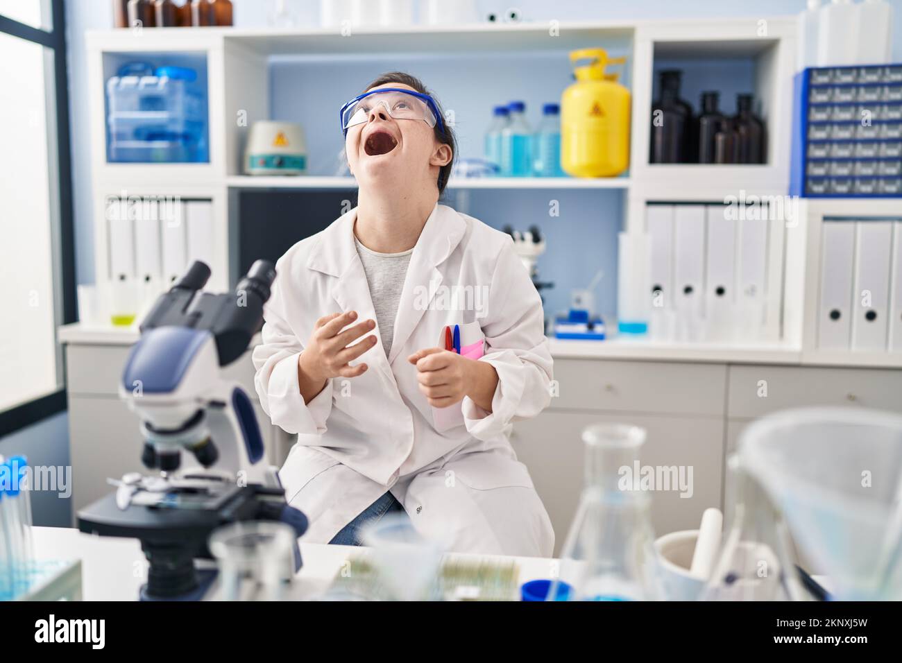 Hispanic girl with down syndrome working at scientist laboratory angry ...