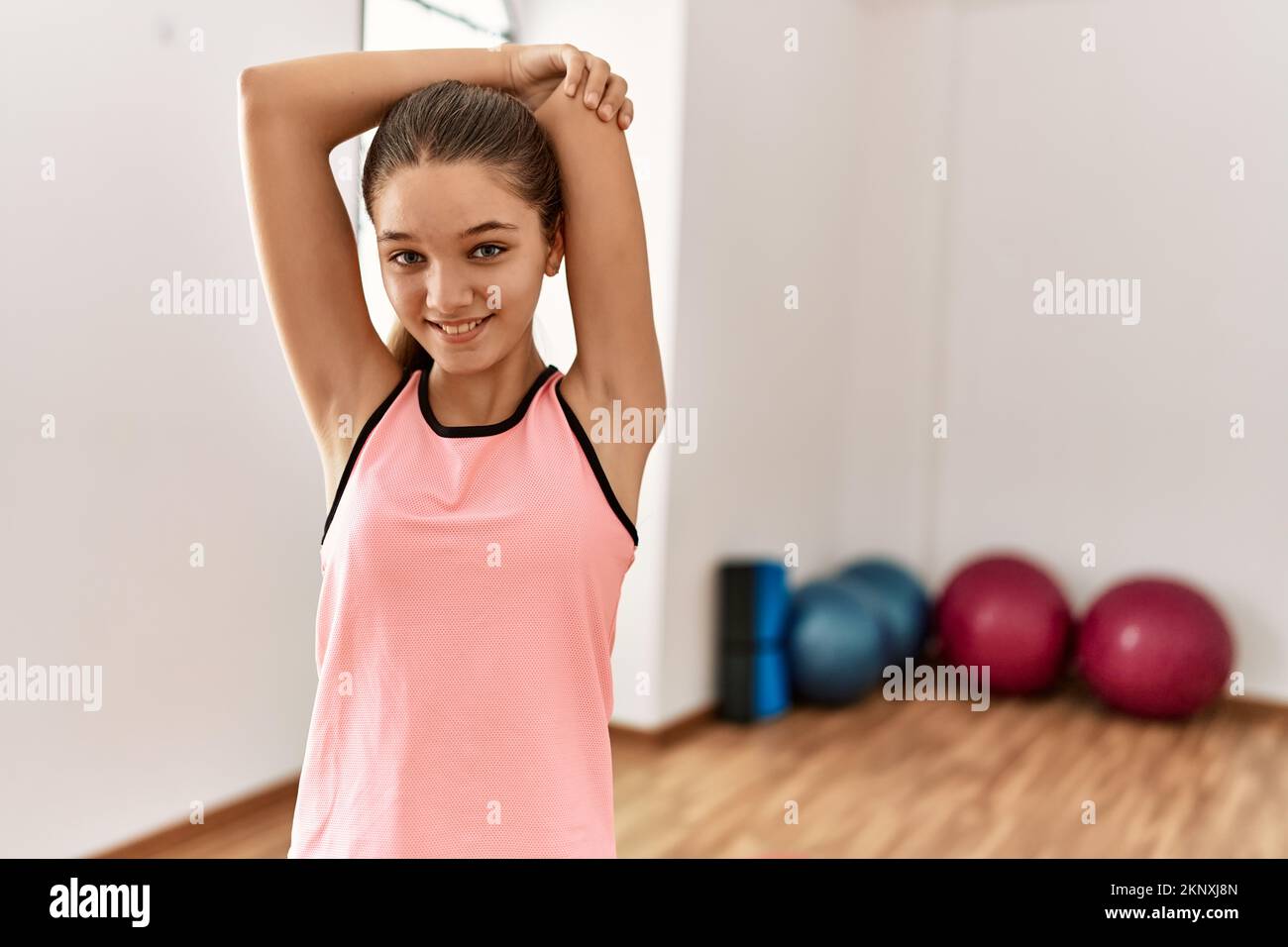 Adorable girl smiling confident stretching at sport center Stock Photo ...